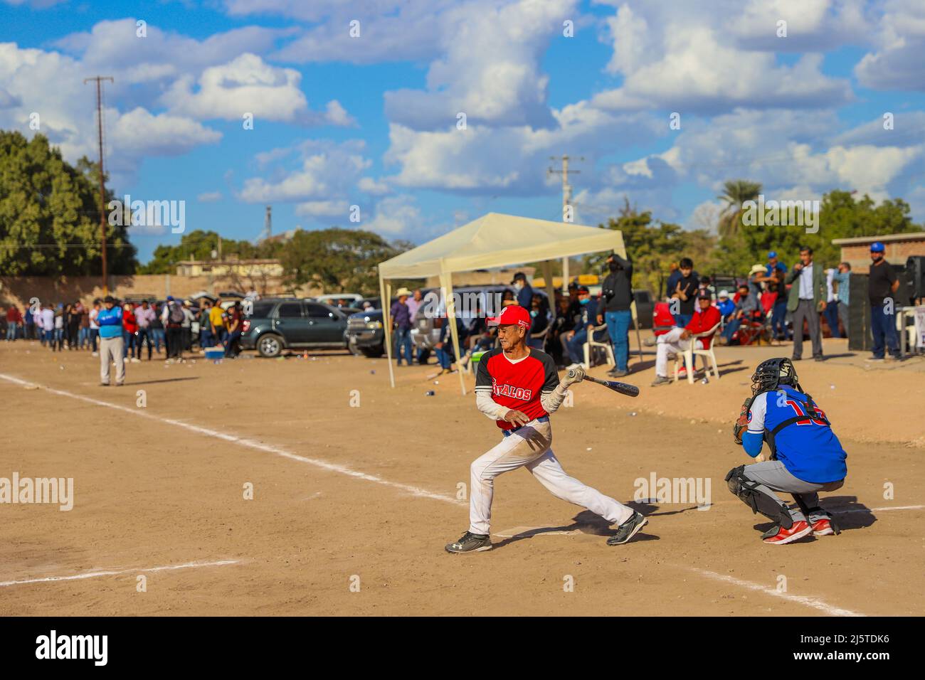 Men watch the llama baseball game on a dirt field. Marte R. Gómez or ...