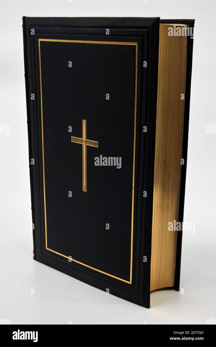 An old bound bible with a gold cross pressed into the leather. The ...