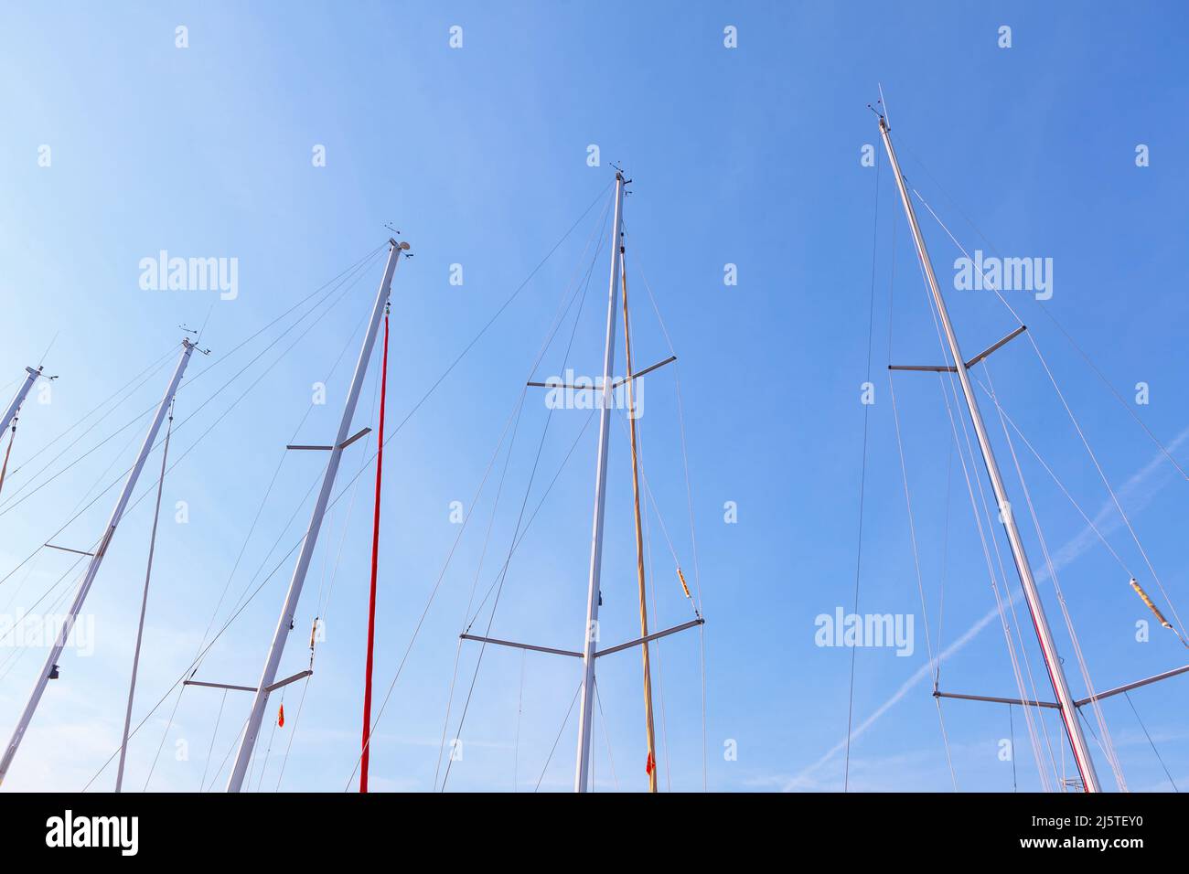 Yacht masts without sails against blue sky Stock Photo - Alamy