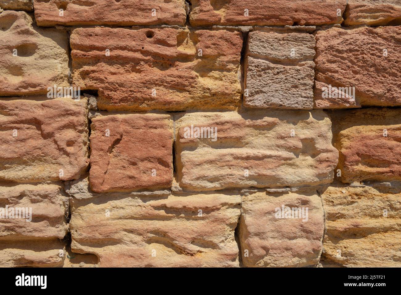 Background with an old wall made of limestone blocks of different sizes ...