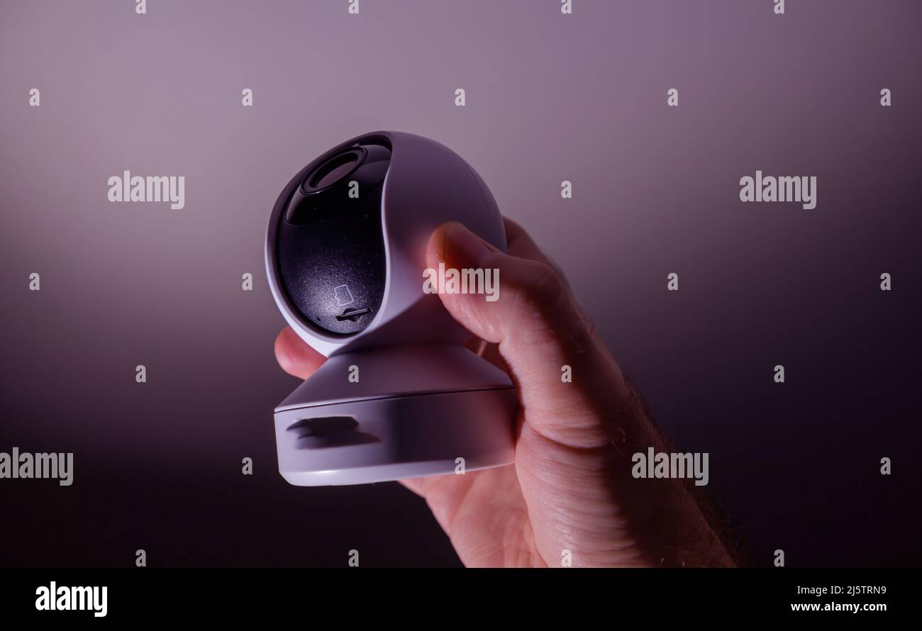 Male hand holding modern tiny 8k UHD surveillance camera with the ...