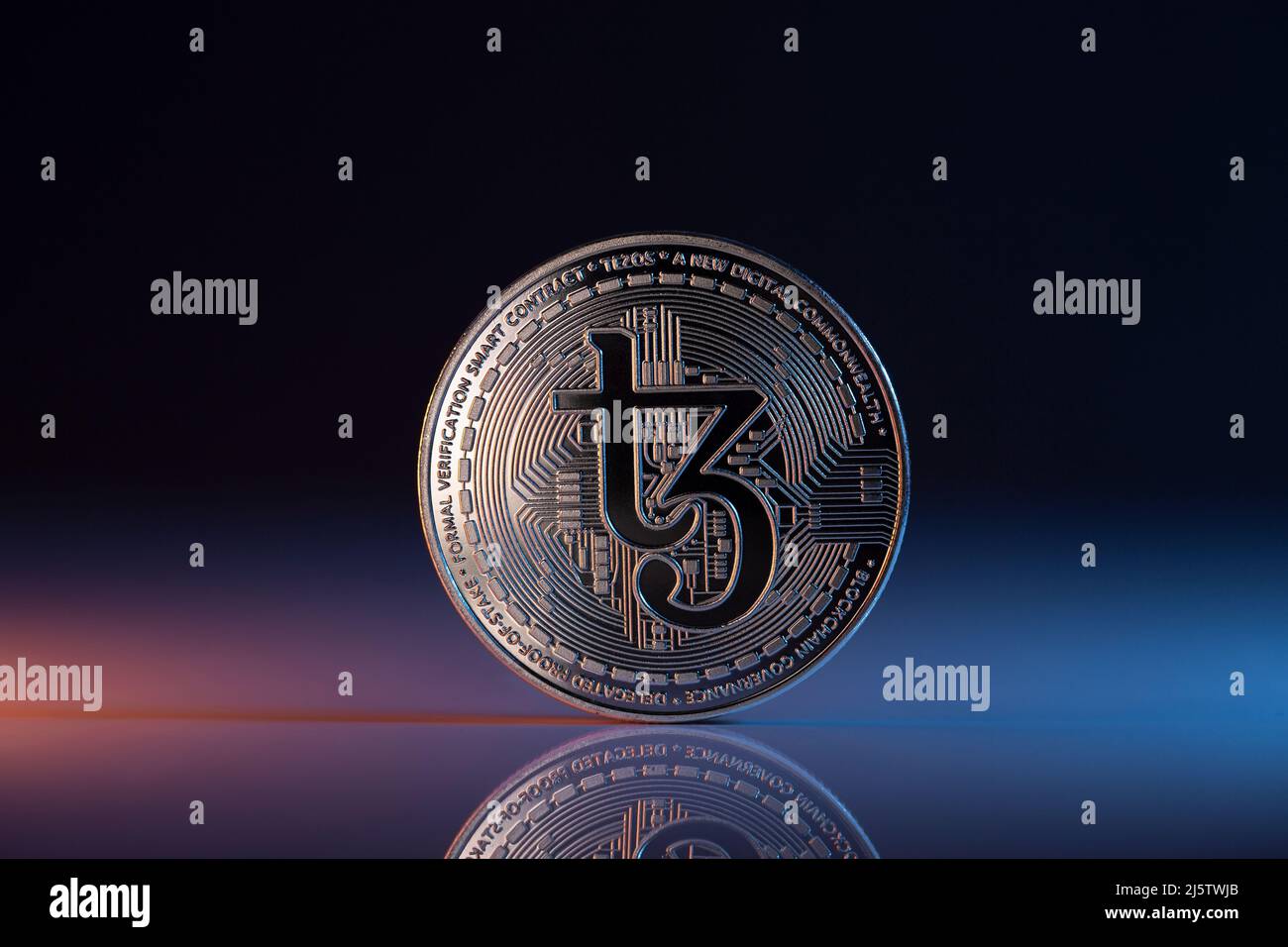 Tezos XTZ Cryptocurrency Physical Coin placed on reflective surface and ...