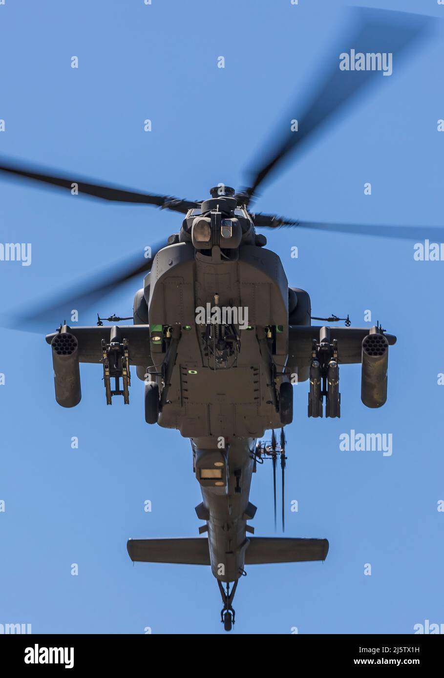 An AH-64 Apache helicopter flies overhead during an aerial gunnery ...