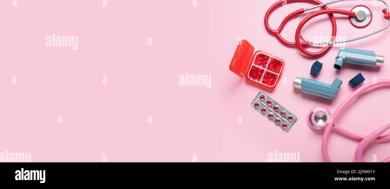 Asthma inhalers, stethoscopes and pills on pink background with space ...