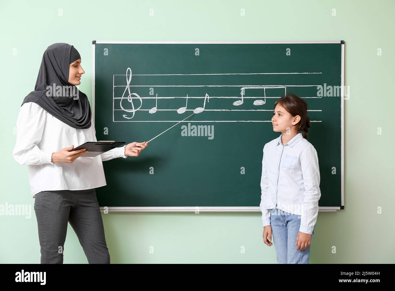 Muslim music teacher giving lesson at school Stock Photo - Alamy