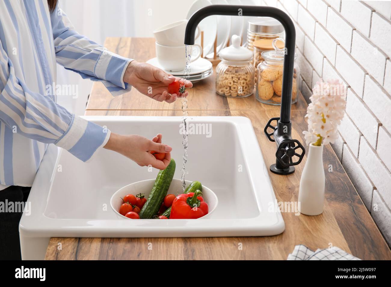 Woman washing fresh vegetables in kitchen sink Stock Photo - Alamy