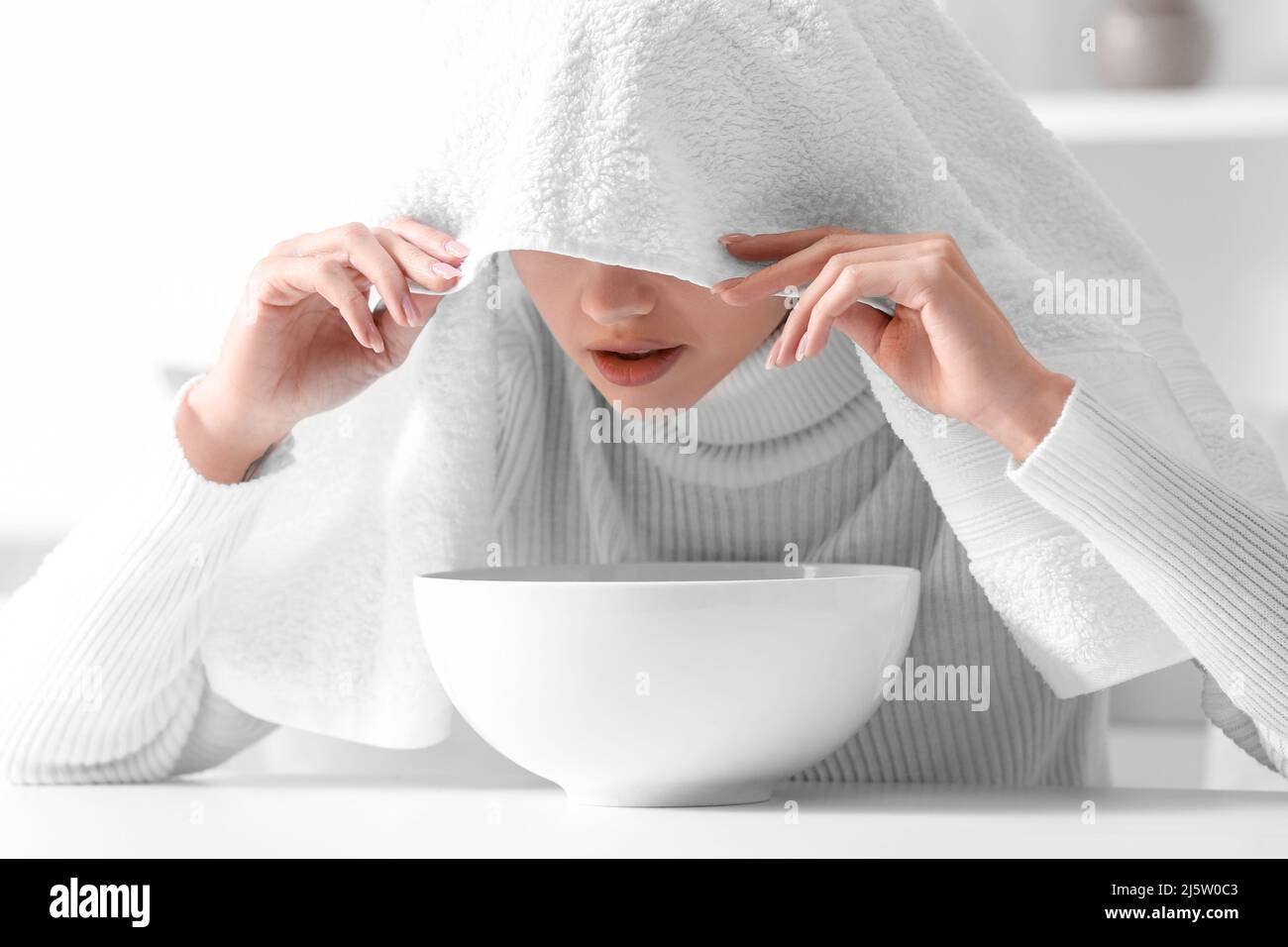 Young woman doing steam inhalation at home to soothe and open nasal ...