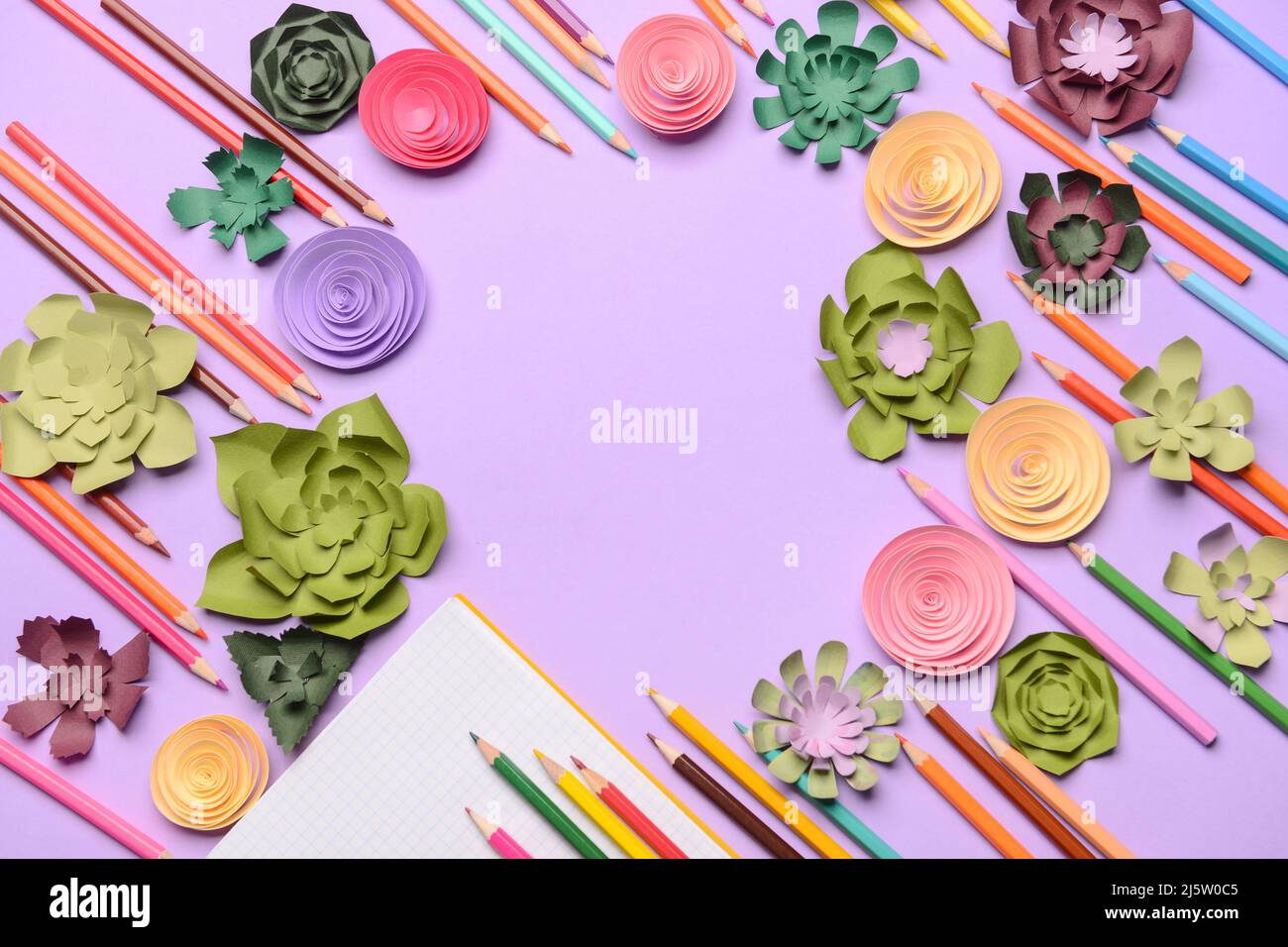 Frame made of different colorful pencils and paper flowers on color ...