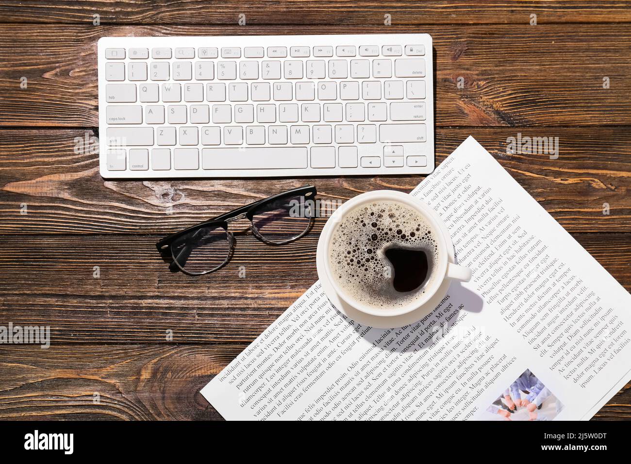 Eyeglasses, computer keyboard and cup of coffee on wooden background ...