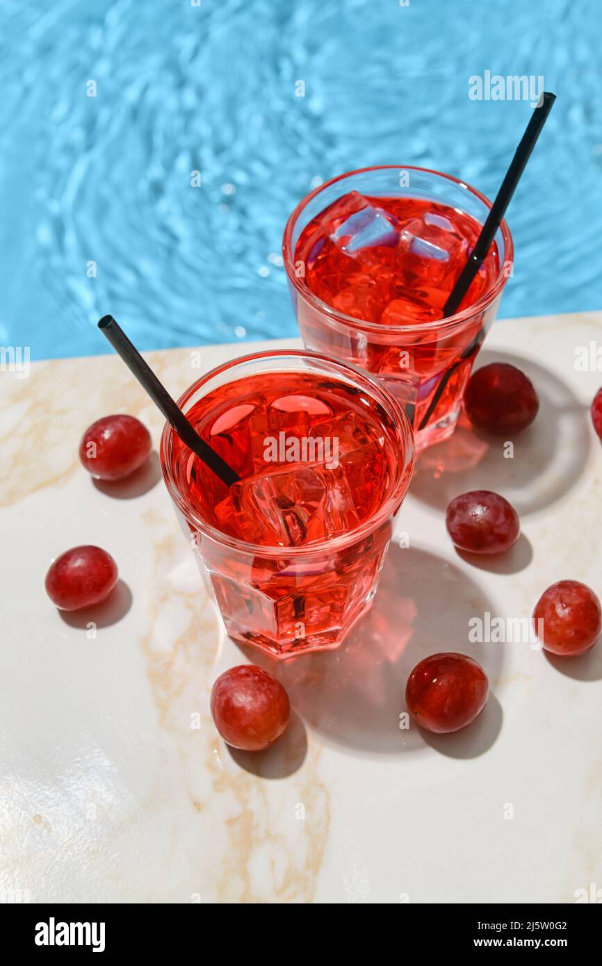Glasses of fresh grape soda on edge of swimming pool Stock Photo - Alamy