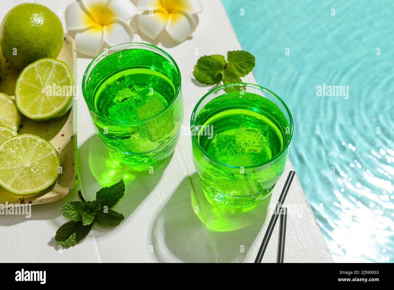 Glasses of fresh lime soda on edge of swimming pool, closeup Stock ...