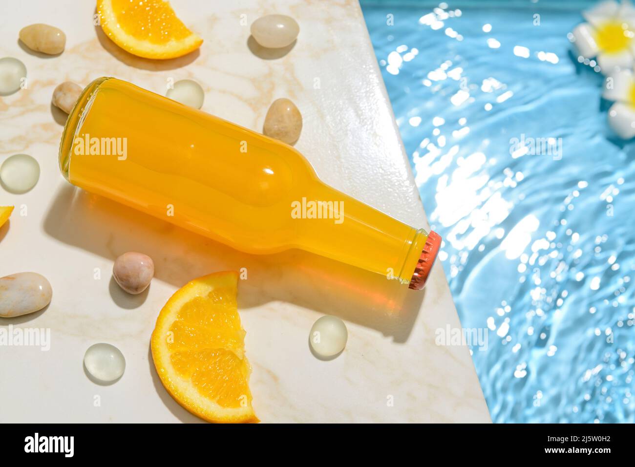 Bottle of fresh orange soda on edge of swimming pool Stock Photo - Alamy