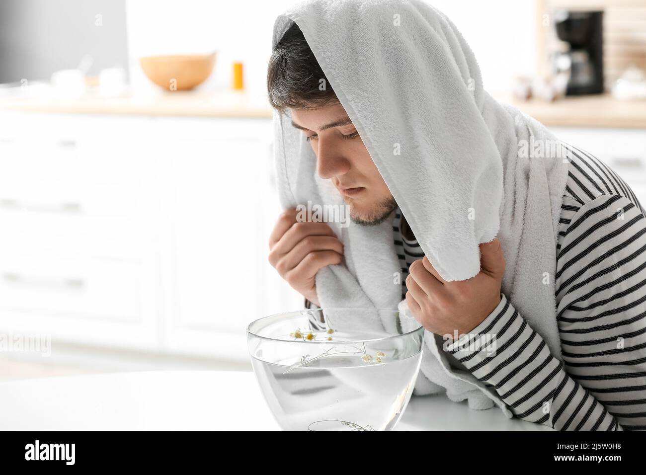 Young man doing steam inhalation at home to soothe and open nasal ...