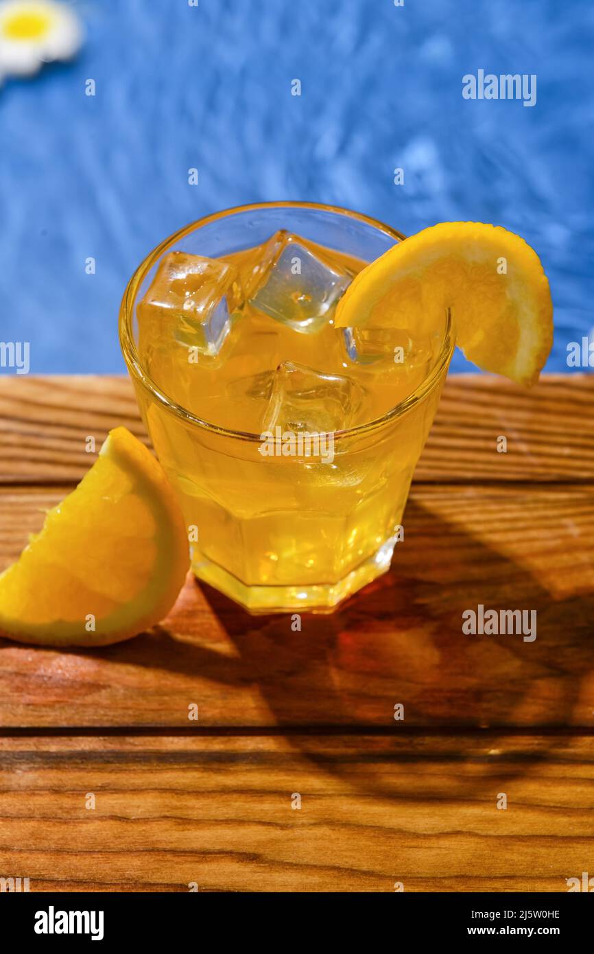 Glass of fresh orange soda on edge of swimming pool, closeup Stock ...