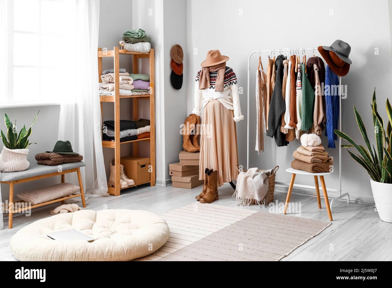 Interior of light dressing room with mannequin, rack and warm sweaters ...