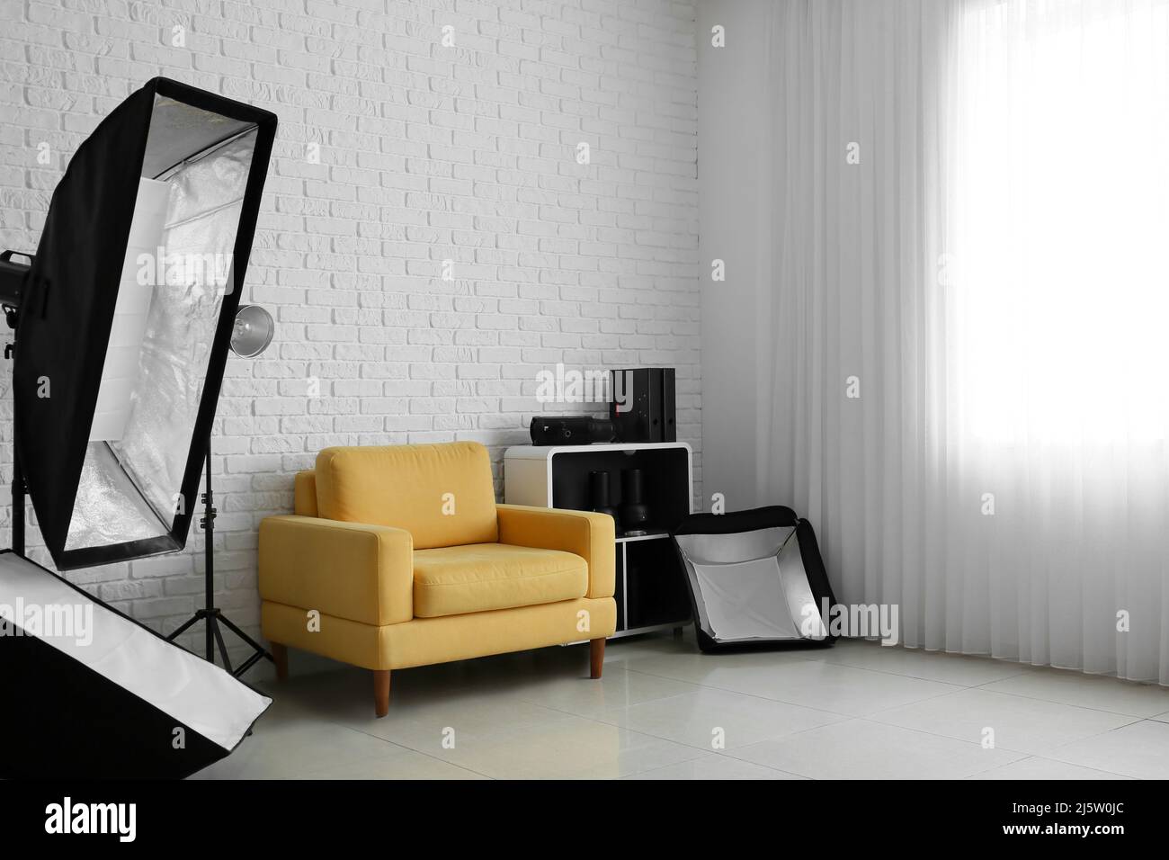 Interior of modern photo studio with armchair and different equipment ...