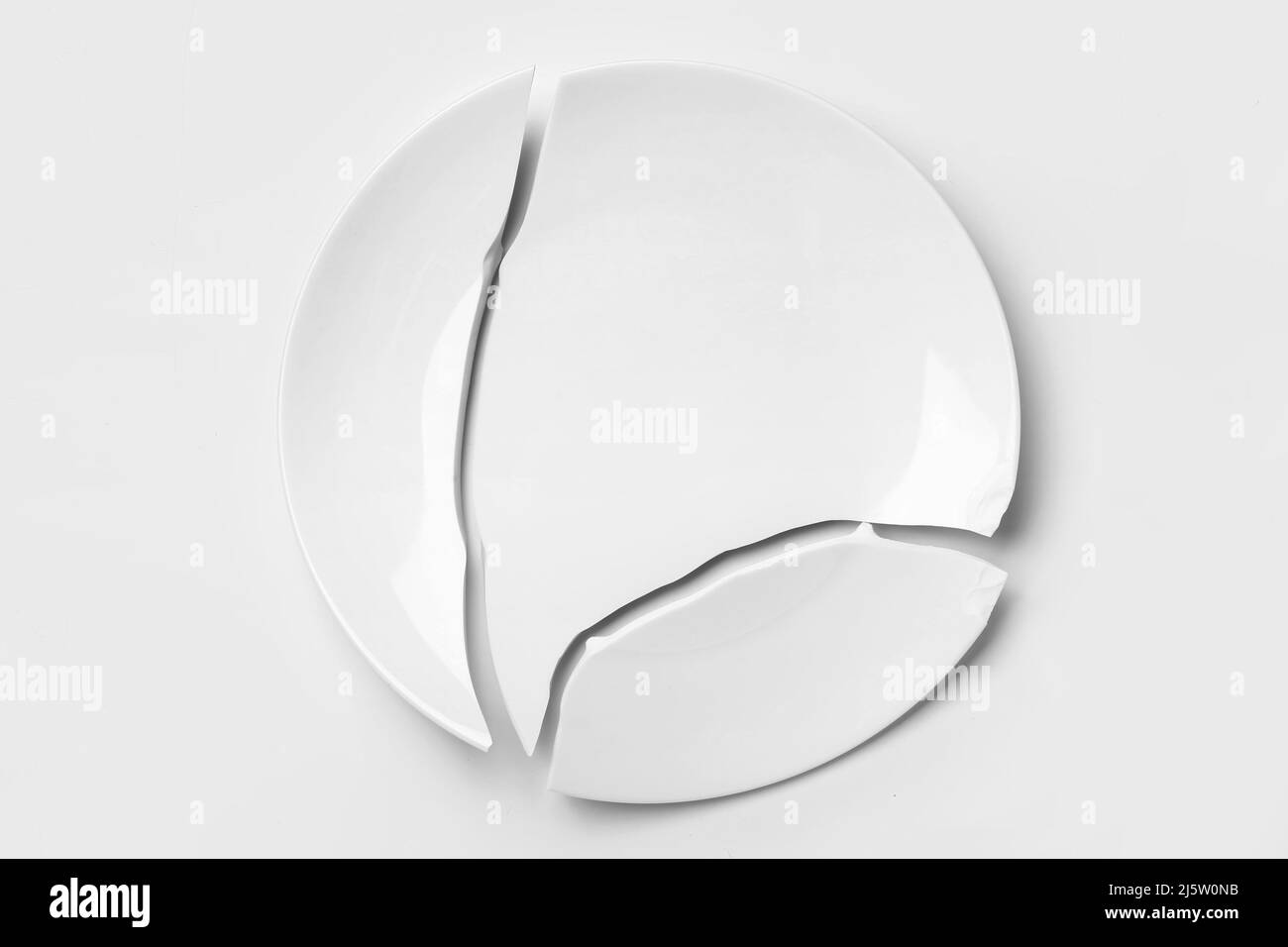 Broken ceramic plate on white background Stock Photo - Alamy