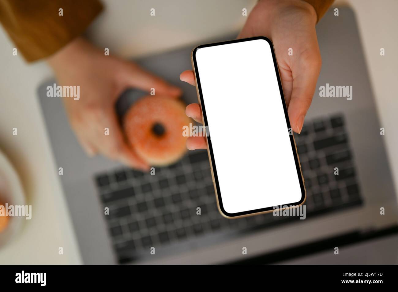 Overhead shot, Female hand holding a smartphone white screen mockup ...