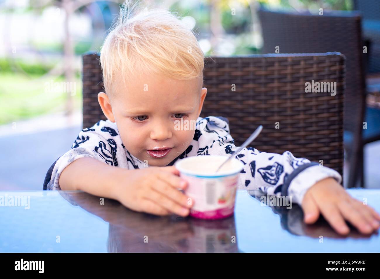 Baby eating kids food. Little boy eating yogurt, have a breakfast in ...