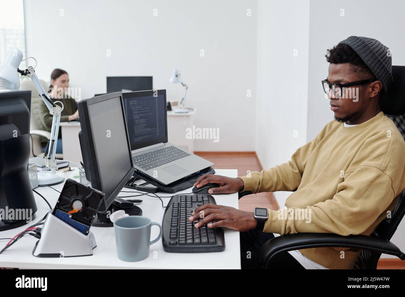 Young African American it developer in casualwear decoding data while ...