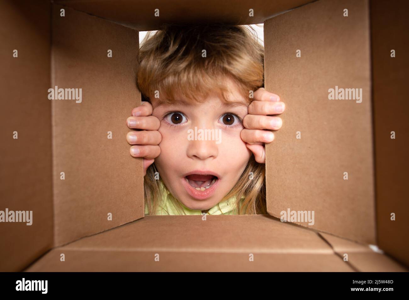 Unpacking cardboard box for kids. Cheerful cute child opening a present ...