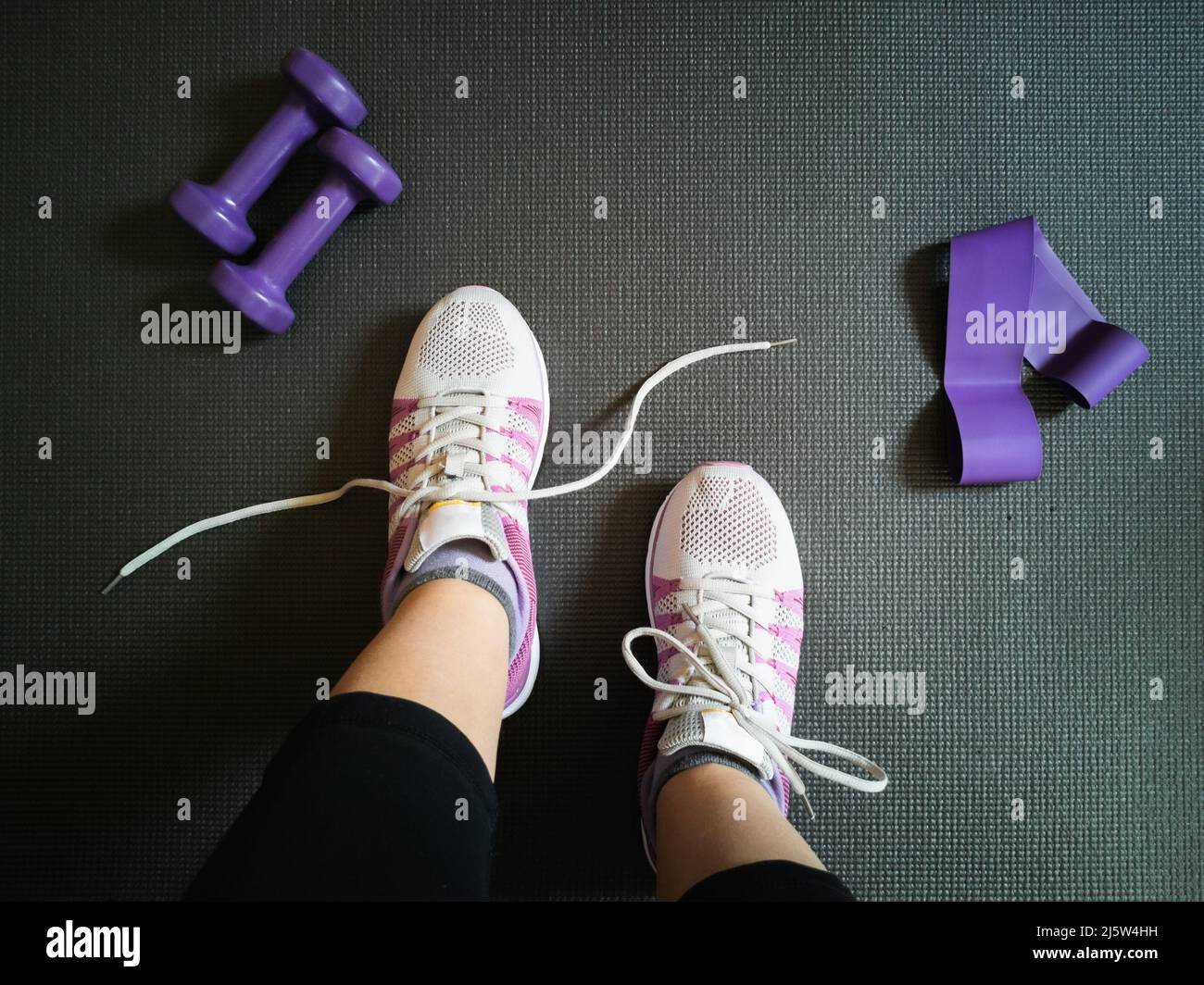Top view of female legs in sneakers on black background Stock Photo - Alamy