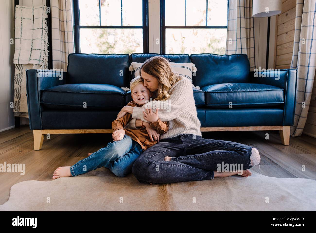 Caucasian mother snuggles with preschool age boy in cabin Stock Photo ...