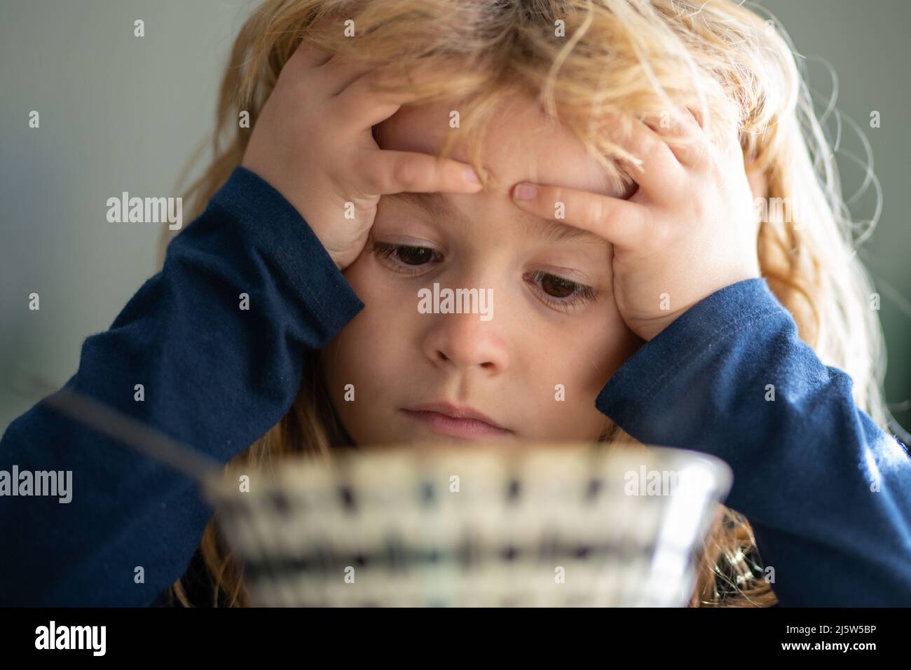 Portrait of sad child having breakfast at home. Portrait of sweet ...