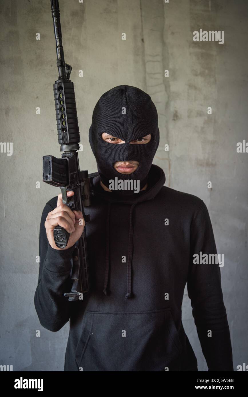 Portrait robbery man standing is holding M16 gun on hand, kidnapping ...