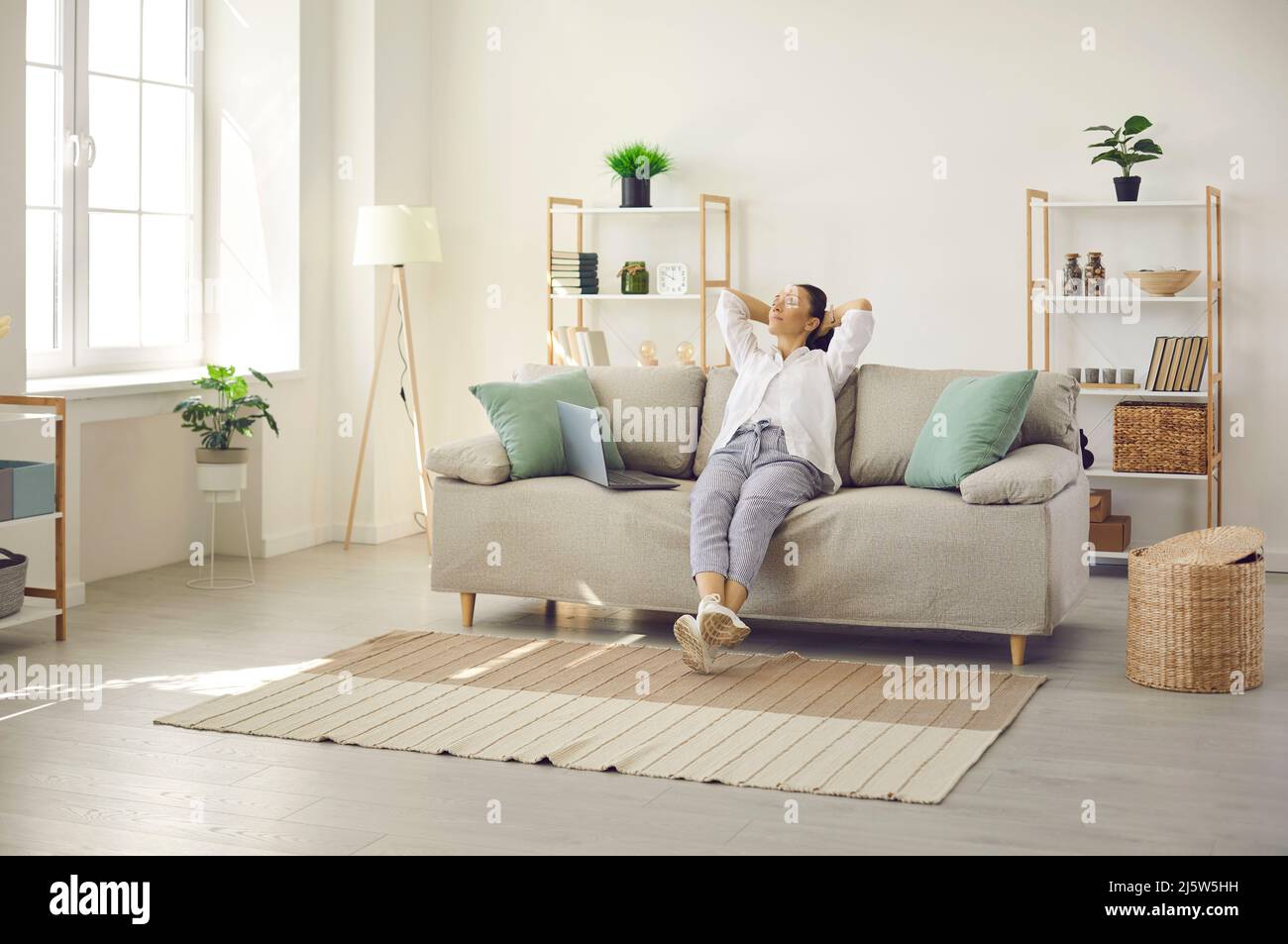 Happy relaxed woman sitting on a comfortable couch in the living room ...