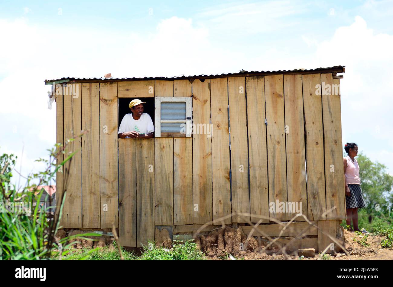 A Malagasy man looking out the window of his small wooden home ...