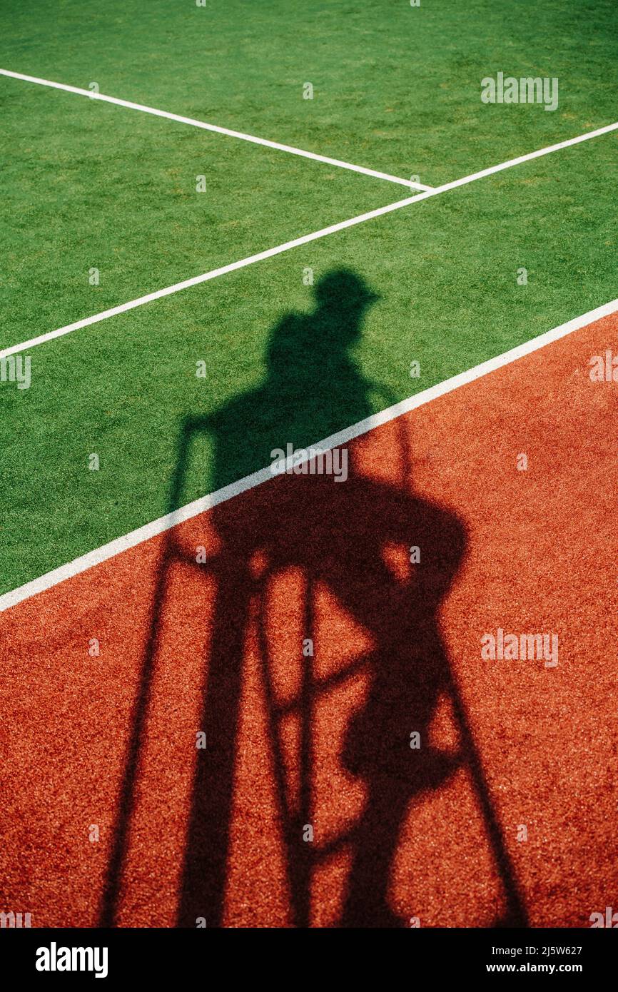 Tennis referee's shadow on a brand new outdoor tennis court. Vibrant ...
