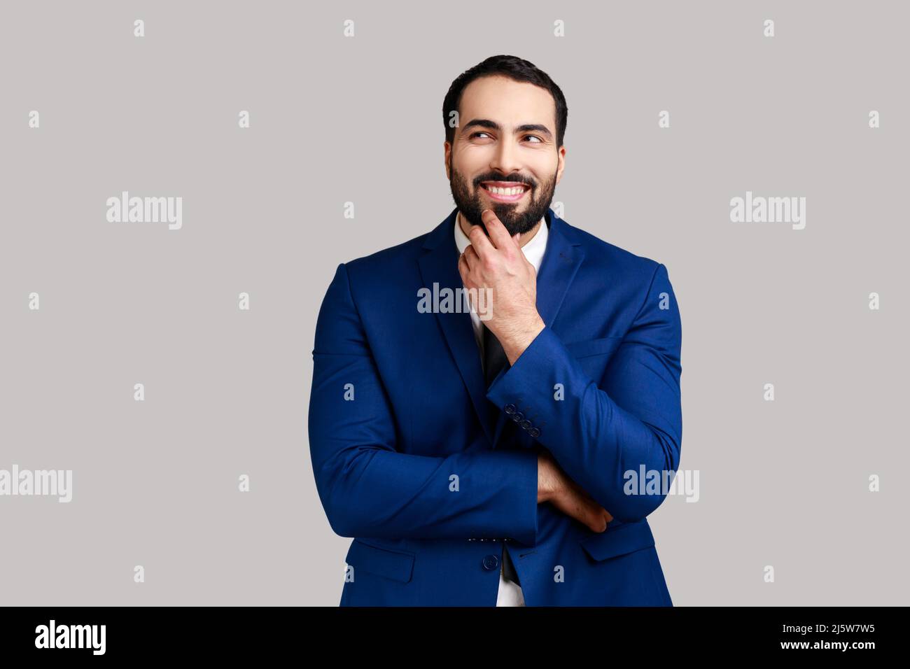 Bearded man with peaceful face thinking over plans for future holding ...