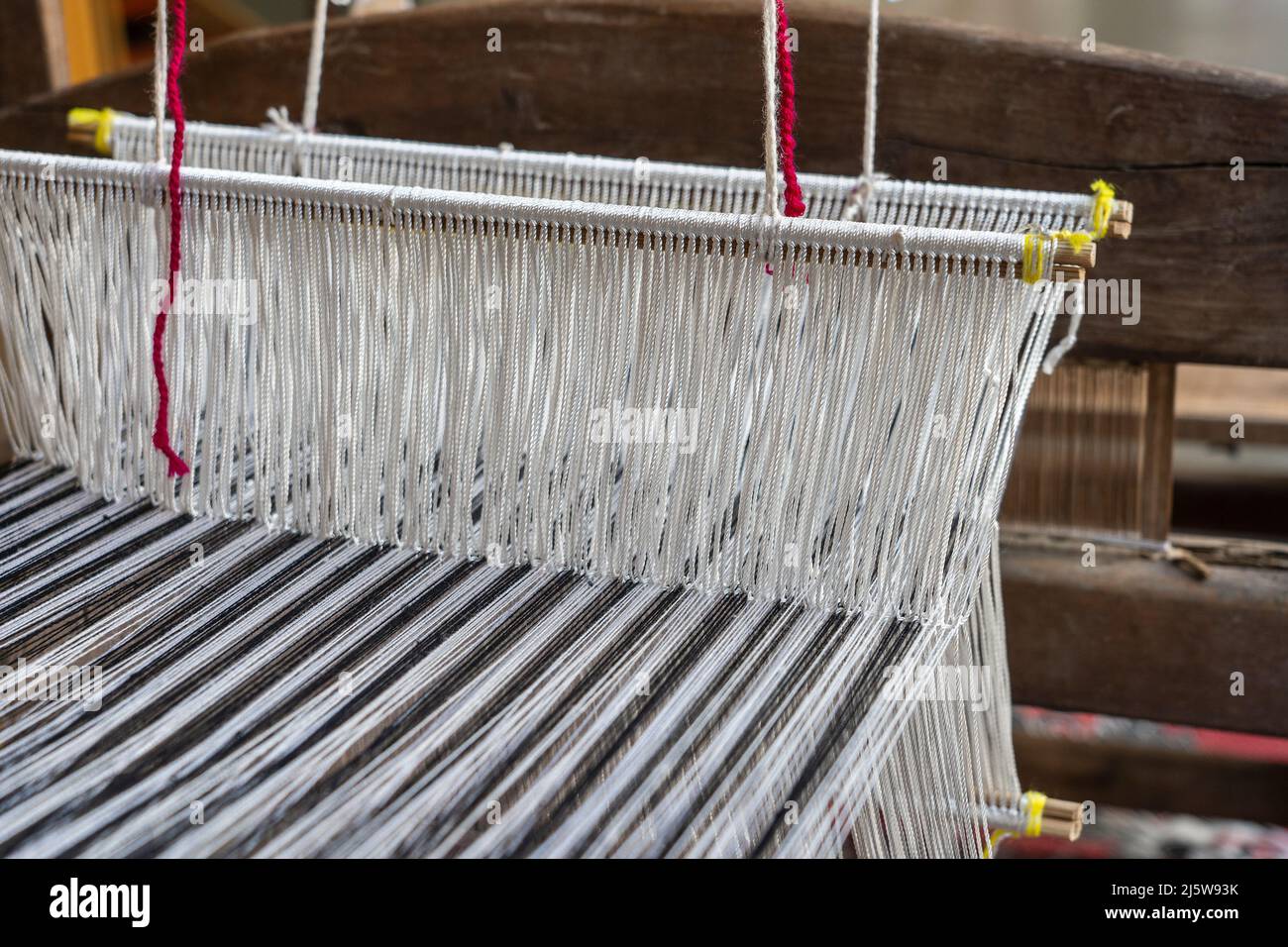 Old hand-weaving vintage wooden loom being used to make fabric, close ...
