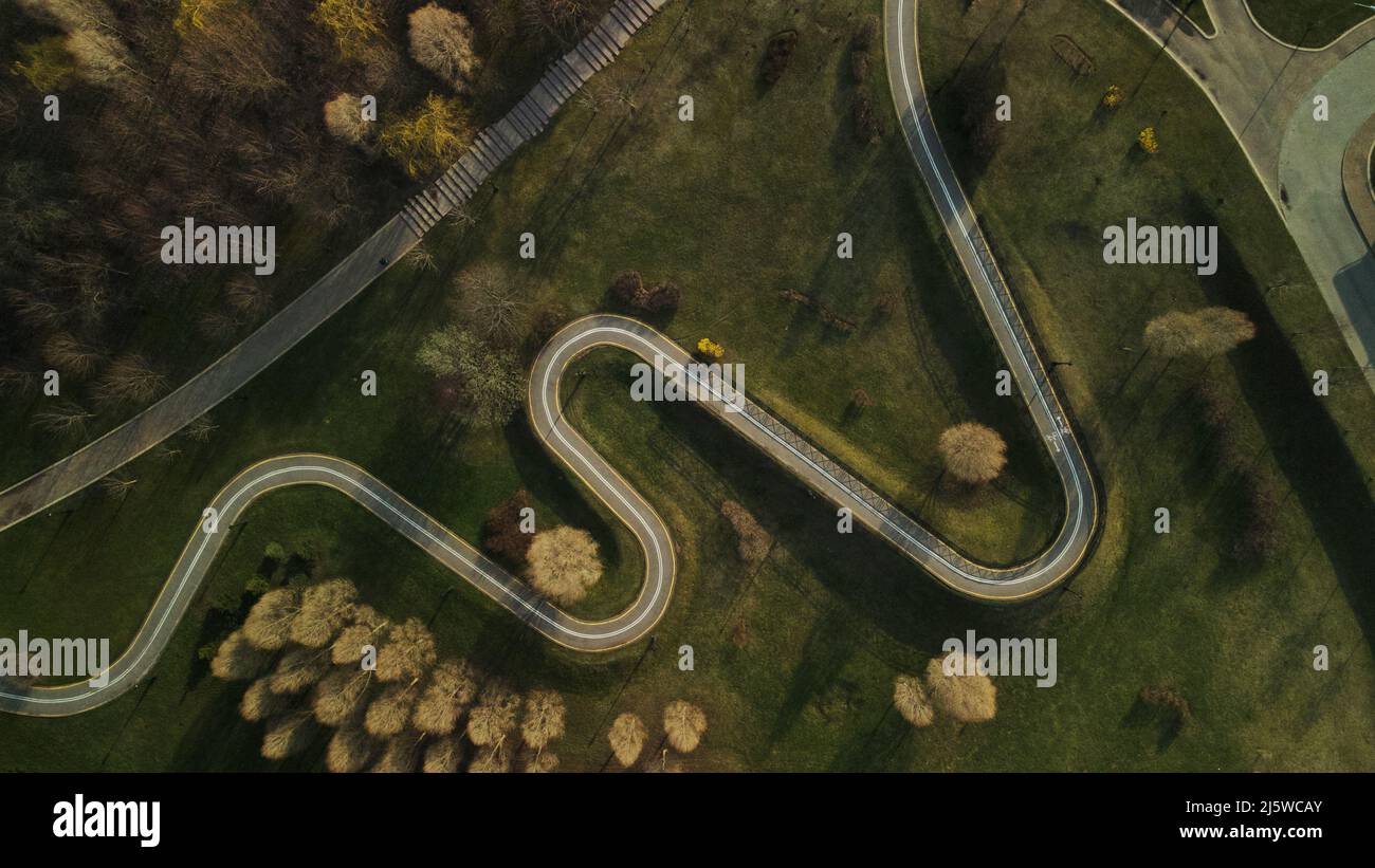 A winding bike path in a city park. Flight over the spring city park ...