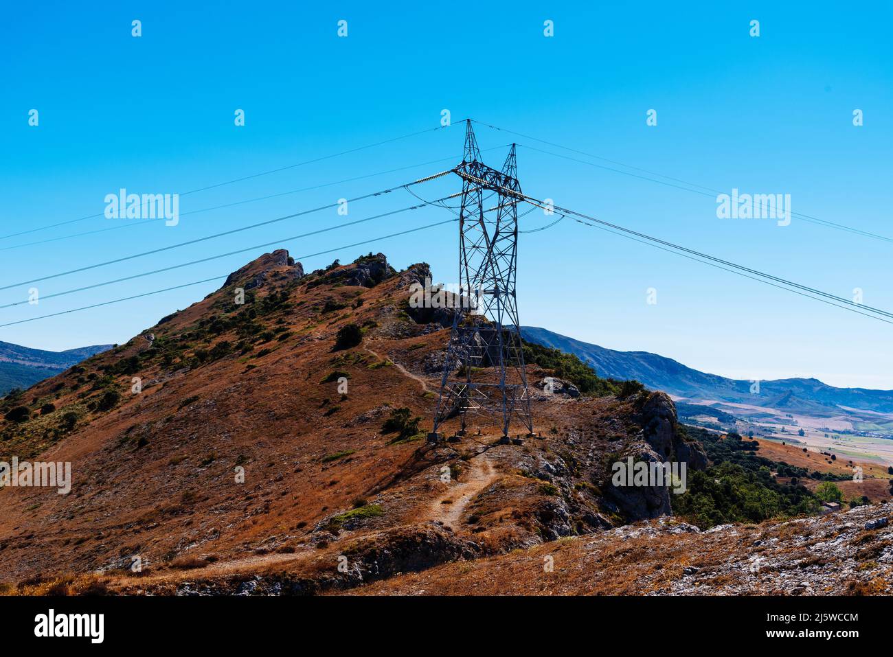 High voltage towers with hanging power cables in a rural landscape ...