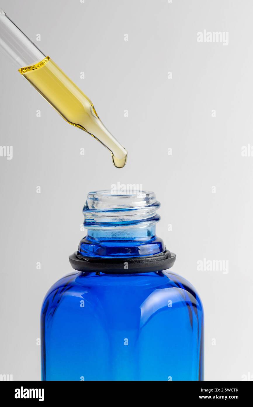 face serum drop with glass dropper bottle jar with pipette on white ...