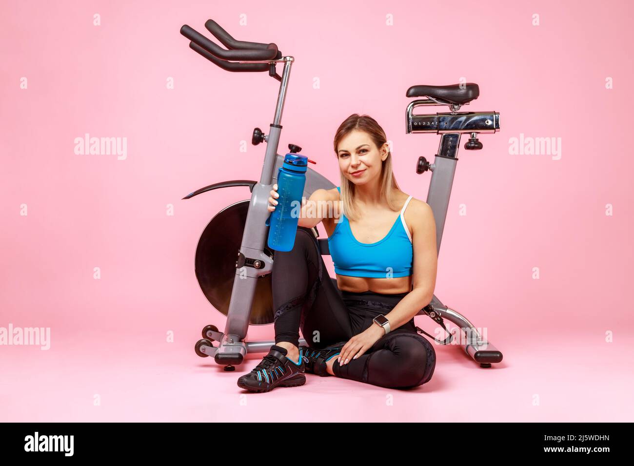 Portrait Of Attractive Athletic Woman Holding Water Bottle Restoring