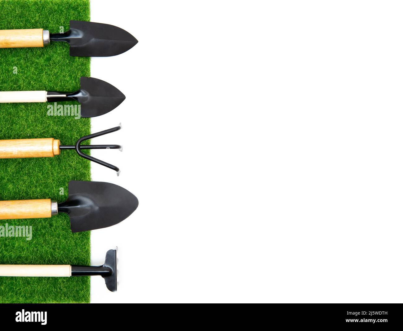 Set of hand held gardening tools on a lawn background with copy space ...