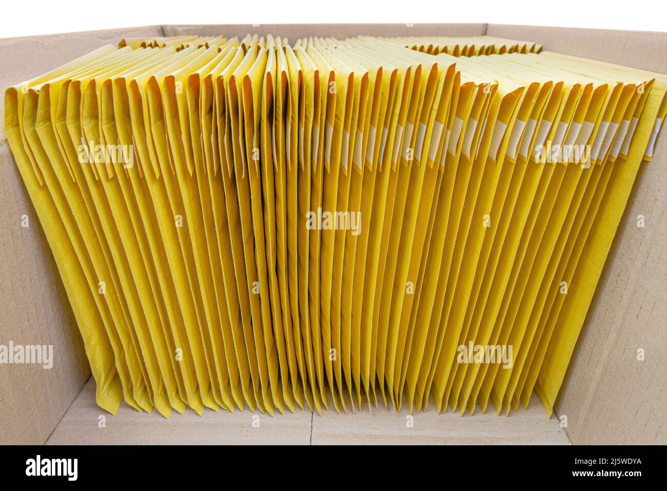Stacks of yellow padded envelopes in a shipping box. Quality control ...