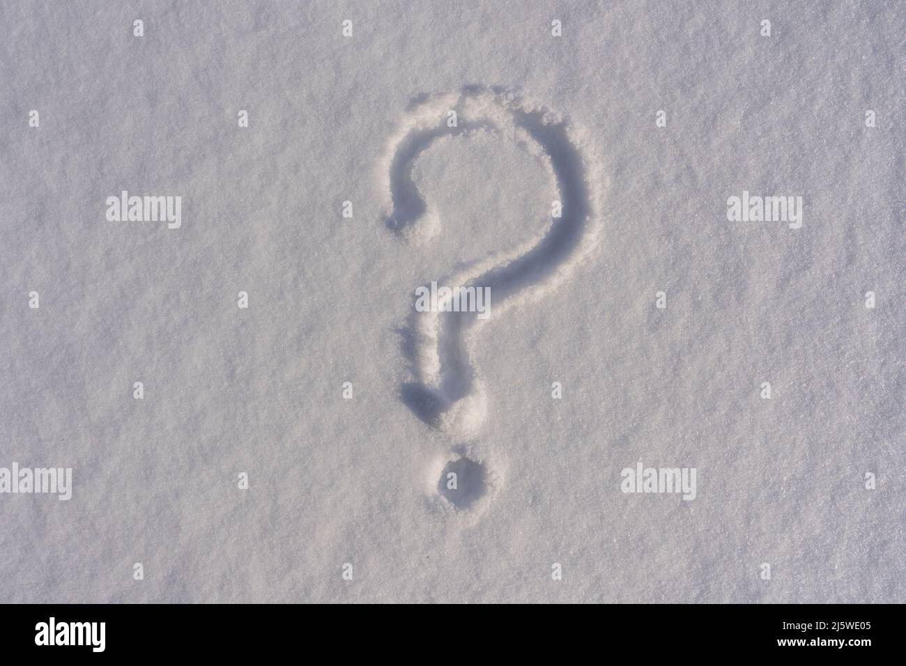 Question mark on a white fresh snow in winter, close up. Question mark ...