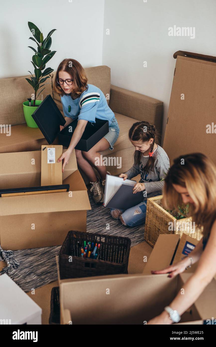 Family unpacking cardboard boxes at new home Stock Photo - Alamy