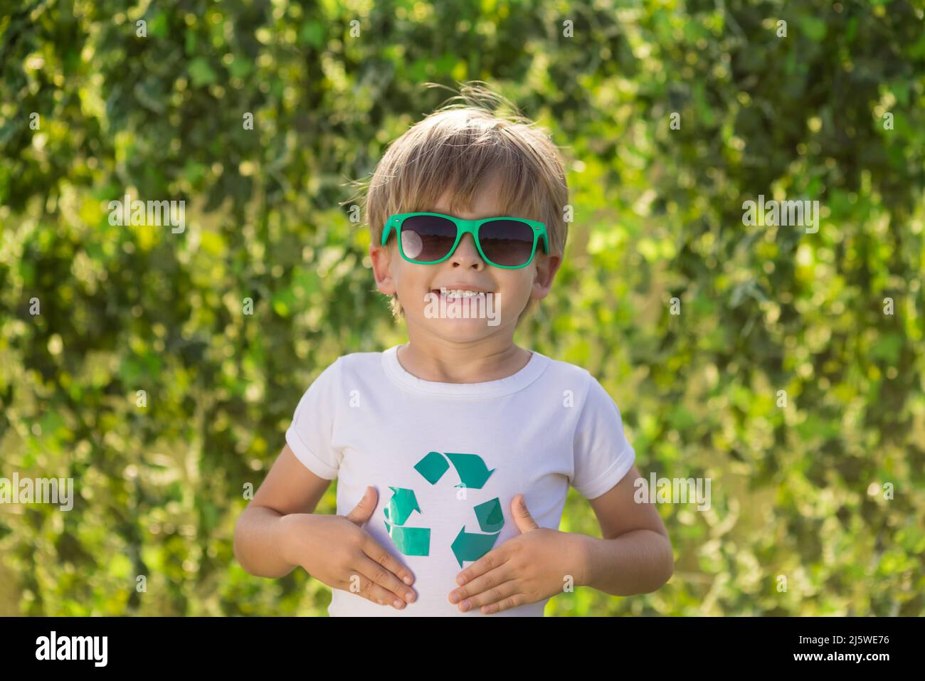 Happy child showing recycle sign. Portrait of kid outdoor. Boy against ...