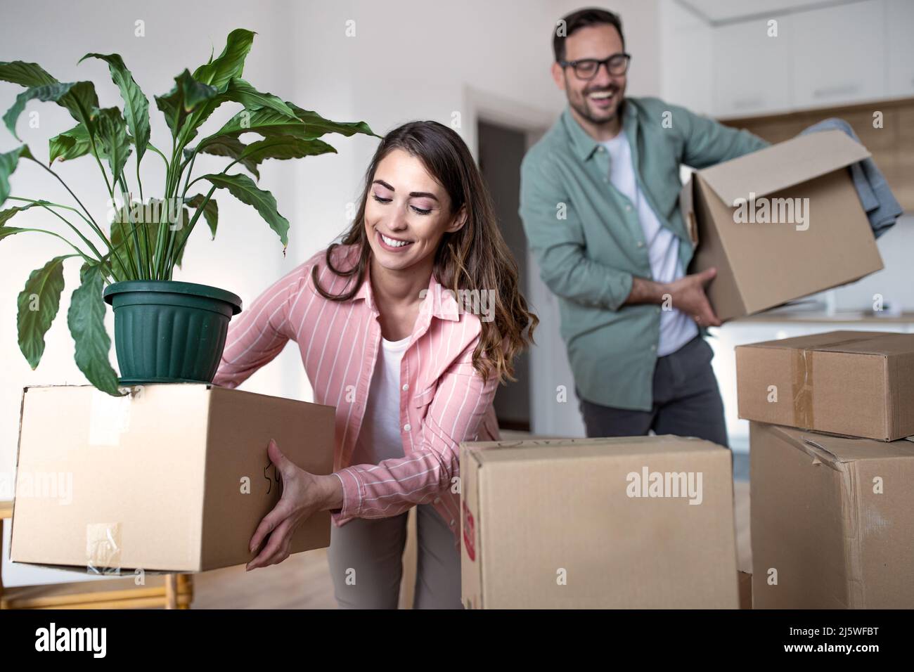 Couple moving in and brings cardboard boxes with their belongings into ...