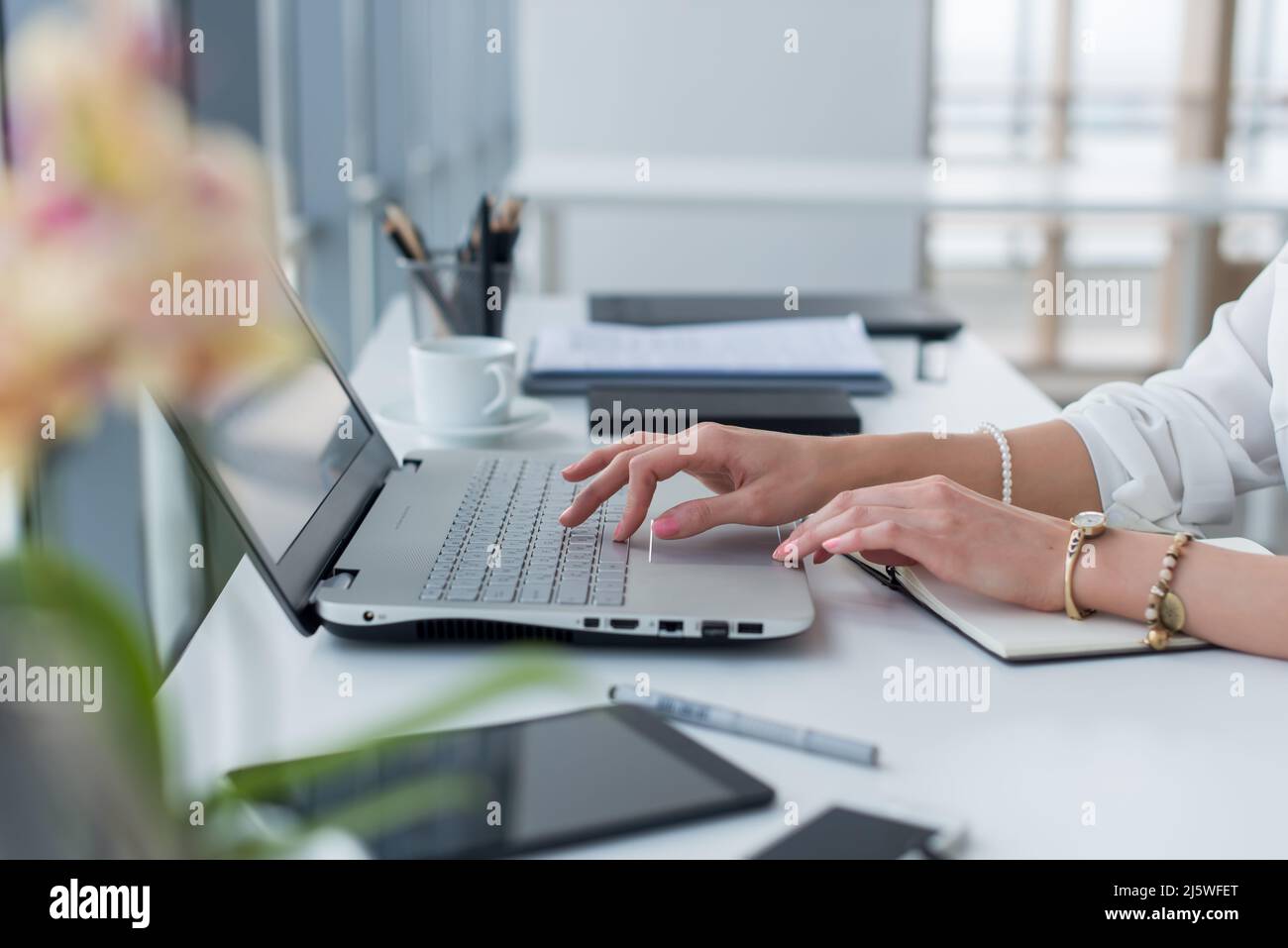 Close-up photo of female hands with accessories working on portable ...