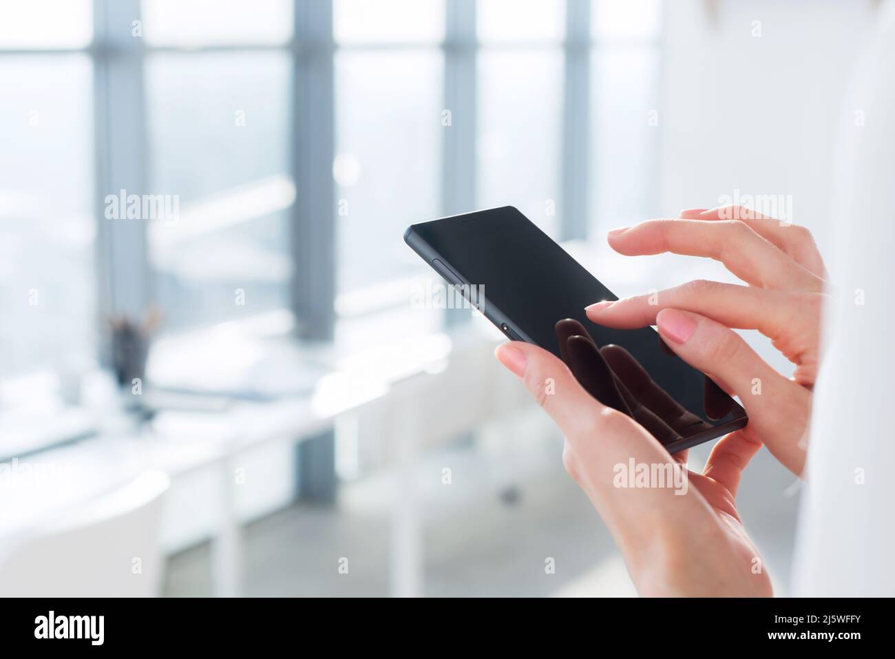 Close-up side view picture of female hands holding smartphone, using ...