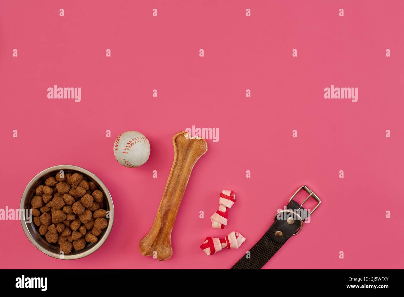 Dog snacks, dog chews, dog bone, ball toy for dog on a pink background ...