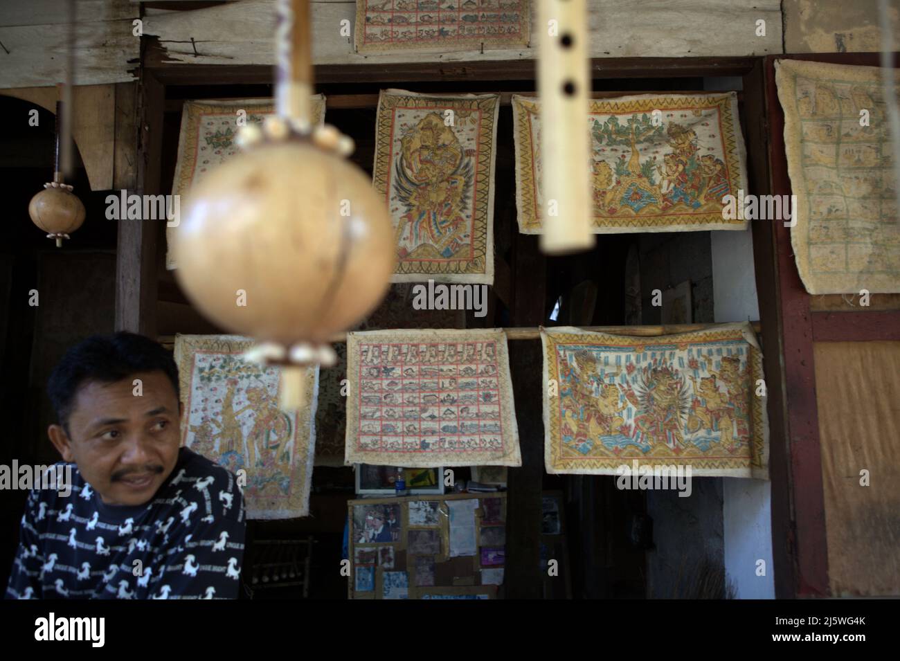 An artist is photographed with old kamasan-style paintings at his ...