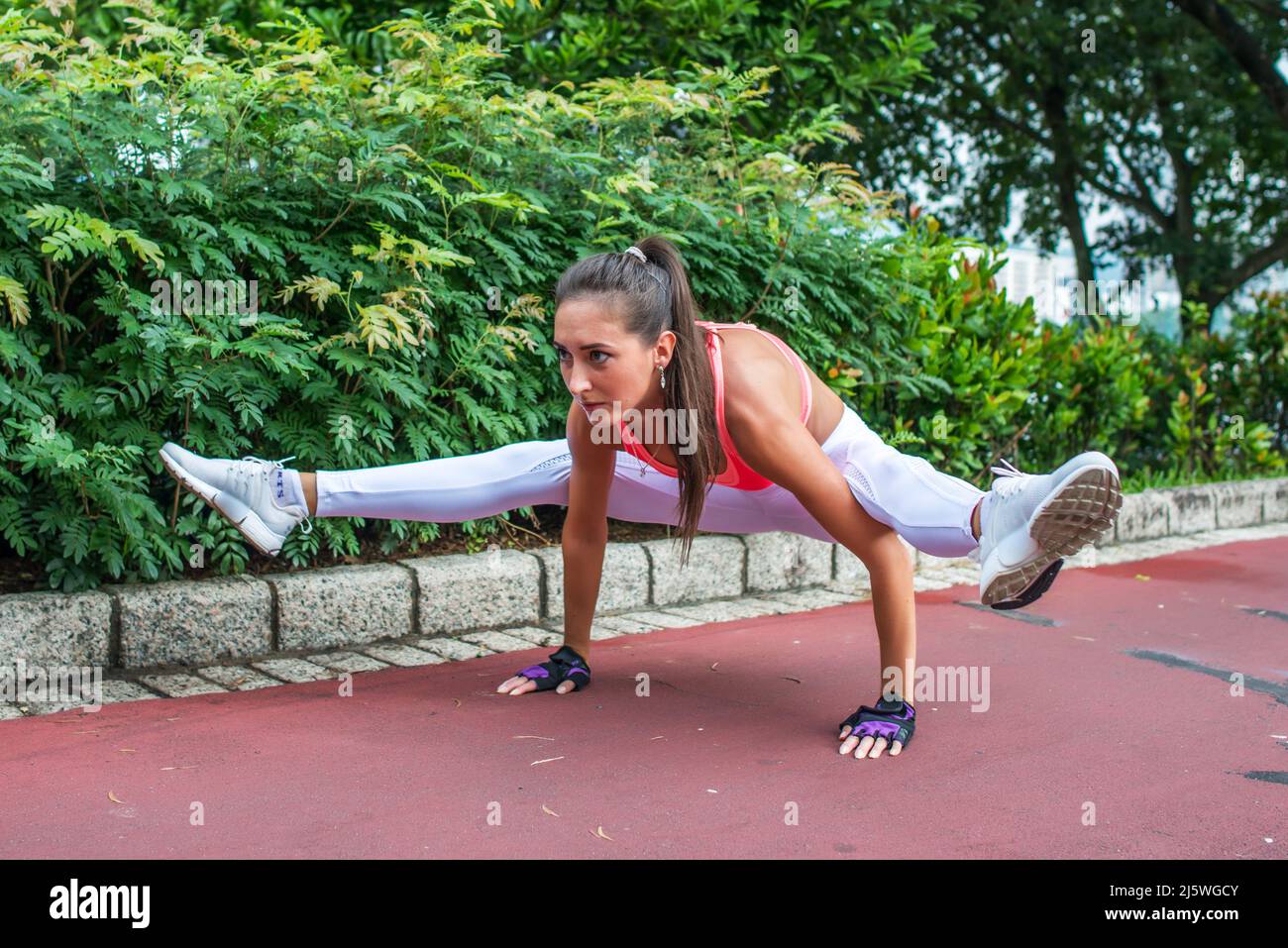Sporty fit young woman doing handstand exercise in firefly posture ...