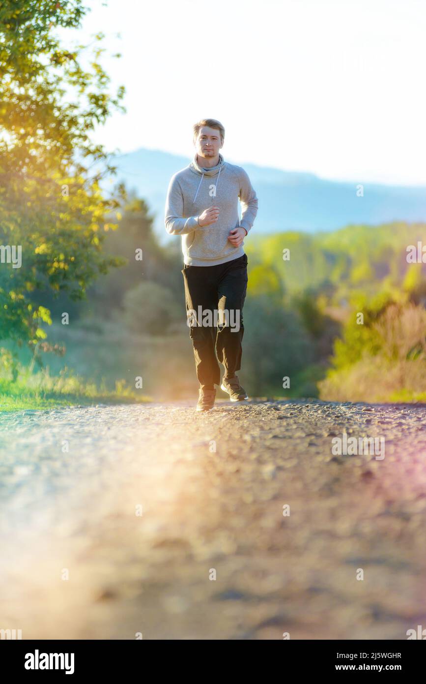 Running man jogging in rural nature at beautiful summer day. Sport ...